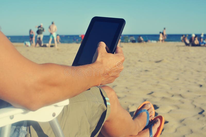Young Man Using a Tablet on the Beach Stock Image - Image of ...