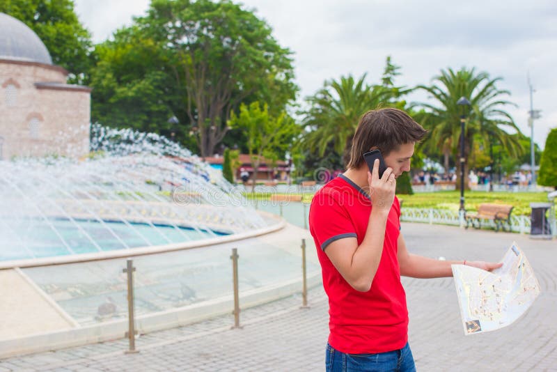 Young Man Using Telephone with Map in Hands Stock Photo - Image of male ...
