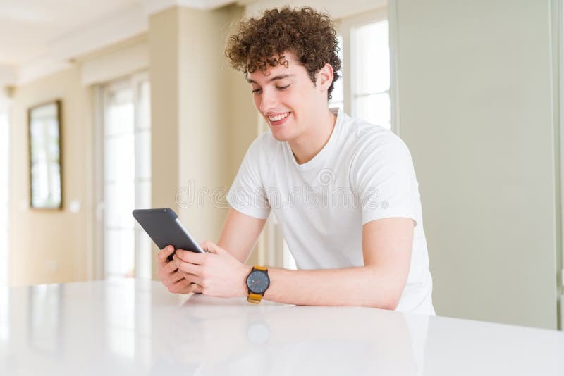 Young Man Using Touchpad Tablet with a Happy Face Standing and Smiling ...