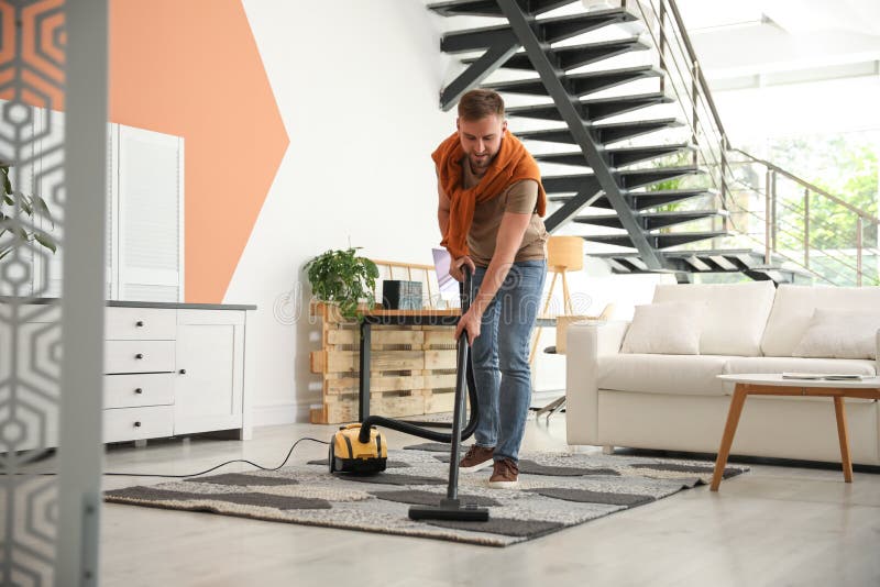 Young Man Using Vacuum Cleaner in Living Room Stock Photo - Image of ...