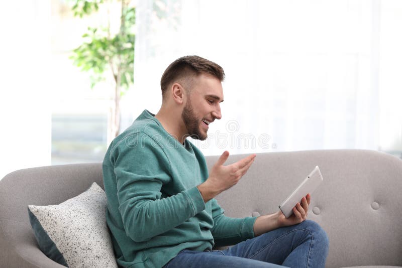 Young Man Using Video Chat on Tablet in Room Stock Photo - Image of ...