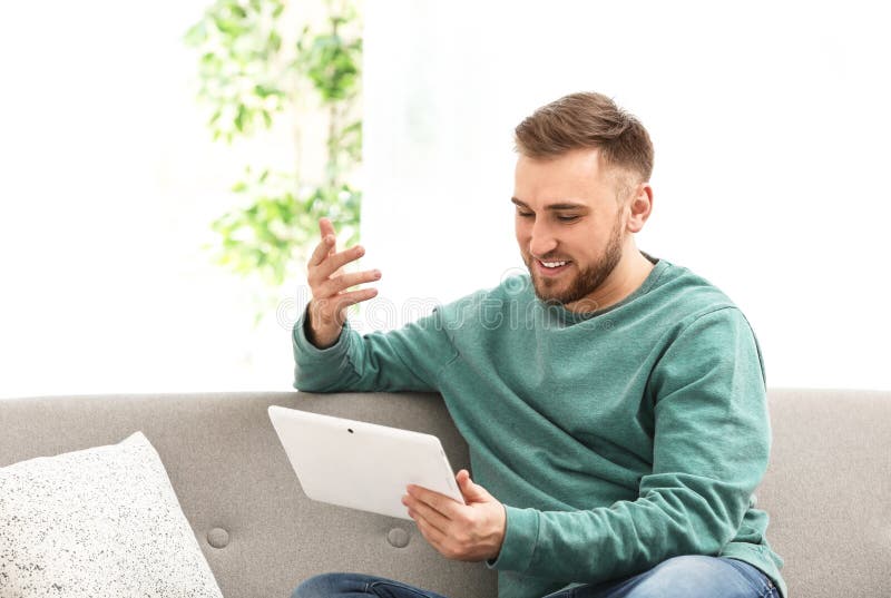 Young Man Using Video Chat on Tablet in Room Stock Photo - Image of ...