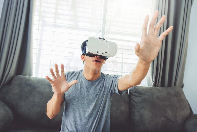 Young Man Using Virtual Reality Glasses Having Fun with VR Simulator at ...