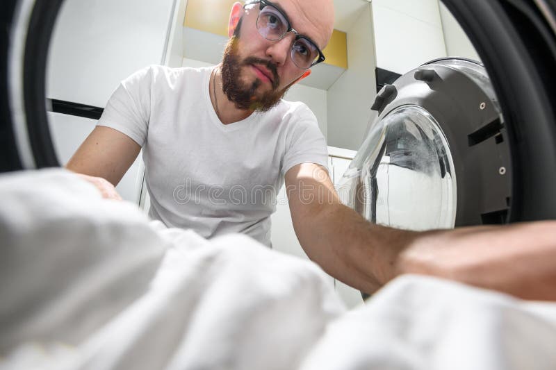 Young Man Using Washing Machine at Home. Laundry Day Stock Photo ...