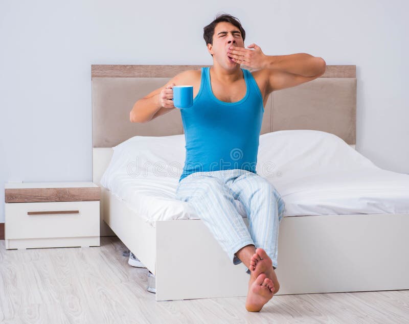 Young man waking up in bed stock image. Image of room - 202627075