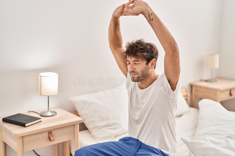Young Man Waking Up Stretching Arms at Bedroom Stock Image - Image of ...