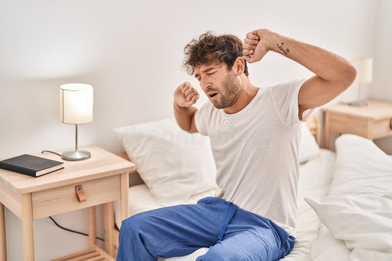 Young Man Waking Up Stretching Arms at Bedroom Stock Photo - Image of ...