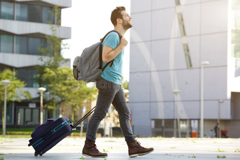 Young Man Walking with Suitcase and Bag Stock Photo - Image of ...