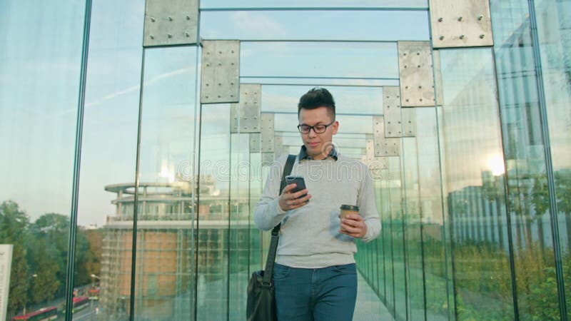 A Young Man Walking and Using a Phone Stock Photo - Image of connection ...