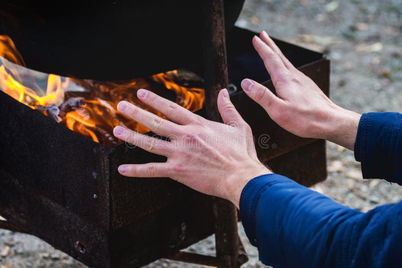 Young Man Warms His Hands by the Fire_ Stock Photo - Image of care ...