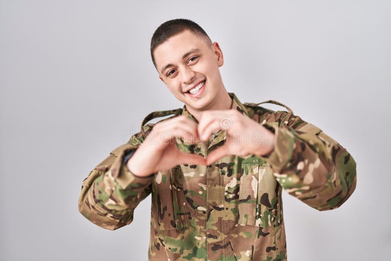 Young Man Wearing Camouflage Army Uniform Smiling in Love Doing Heart ... Young Man Wearing Camouflage Army Uniform Smiling in Love Doing Heart ...