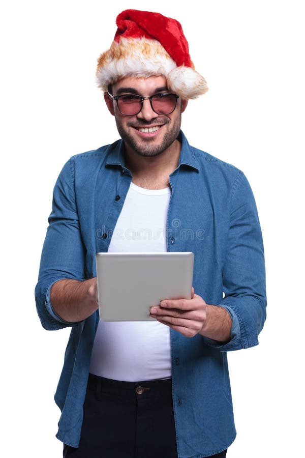 Young Man Wearing Santa Hat is Working on a Tablet Stock Image - Image ...
