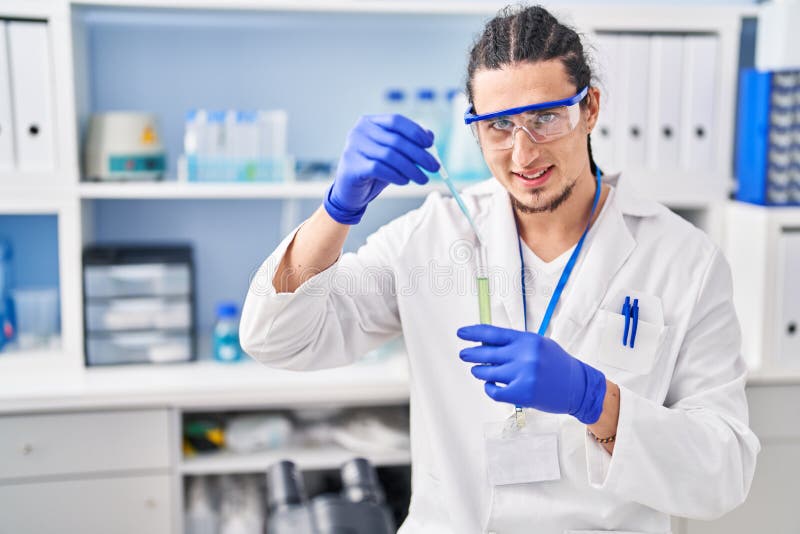 Young Man Wearing Scientist Uniform Measuring Liquid at Laboratory ...