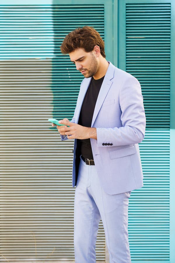 Young Man Wearing a Suit Texting with Smartphone Outdoors. Stock Image ...