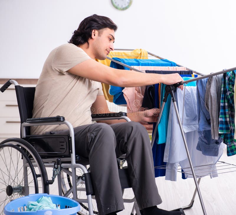 Young Man in Wheel-chair Doing Ironing at Home Stock Photo - Image of ...