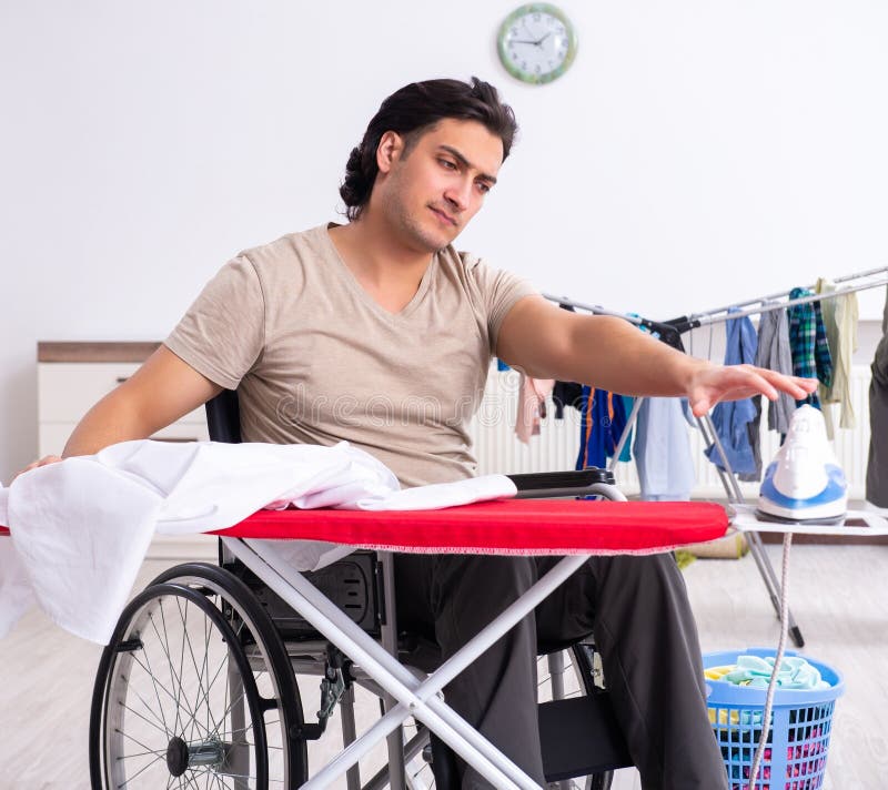 Young Man in Wheel-chair Doing Ironing at Home Stock Photo - Image of ...