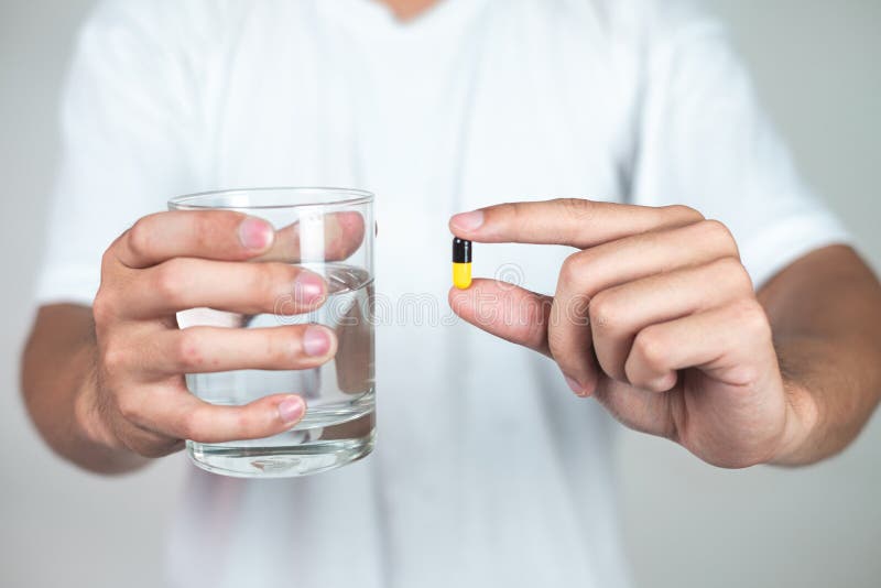 A Young Man in a White Dress is about To Eat a Pill Stock Image - Image ...
