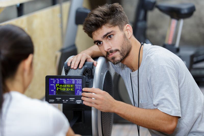 Young Man and Woman on Sitting on Rowing Machine Stock Photo - Image of ...