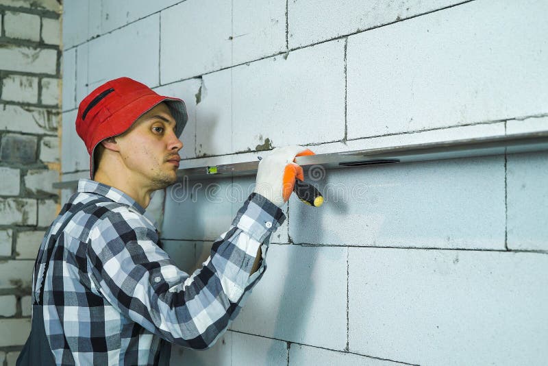 Young Man in Work Wear Checking Straightness of Block Wall with Bubble ...