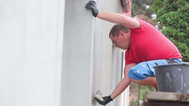 Young Man Worker Application of Glue or Adhesive on the Facade of the ...