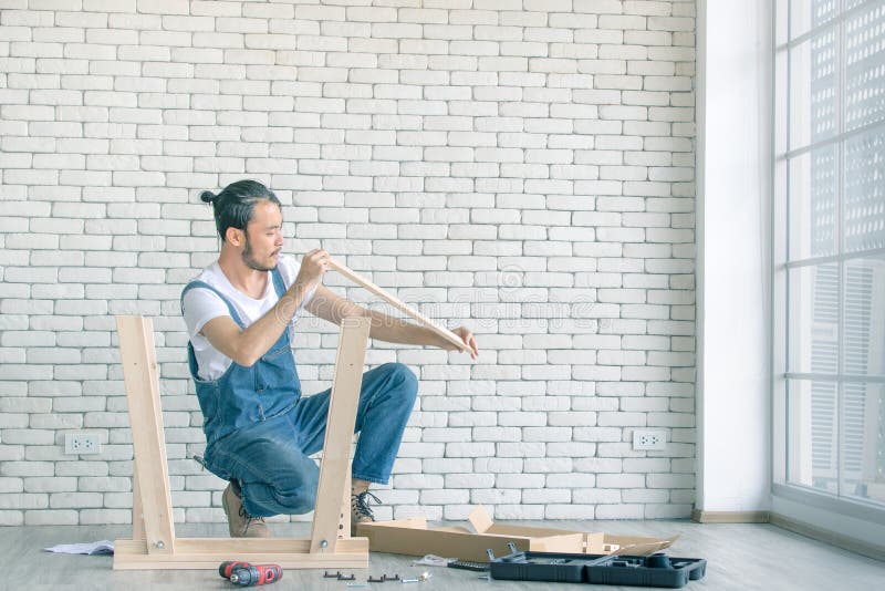 Young Man Working As Handyman, Assembling Wood Table with Equipments ...