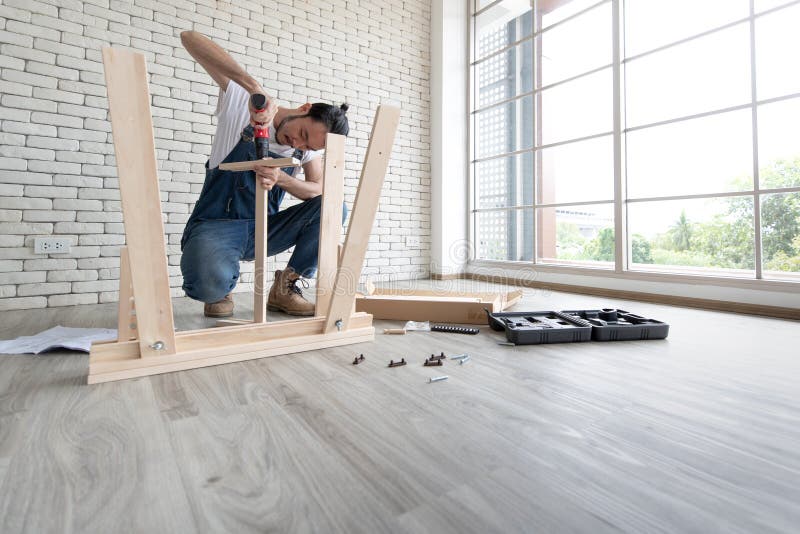 Young Man Working As Handyman, Assembling Wood Table with Equipments ...