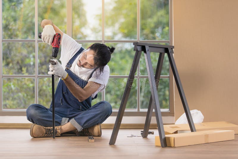 Young Man Working As Handyman, Assembling Wood Table with Equipments ...