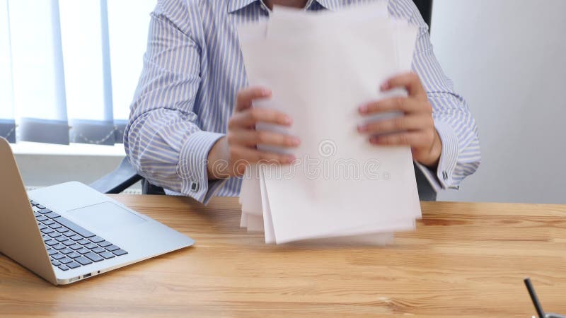 Young Businessman is Gathering Together Paperwork at Desk in Office ...