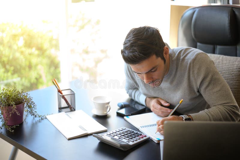 A Young Man Working at a Desk with a Laptop. Stock Image - Image of ...