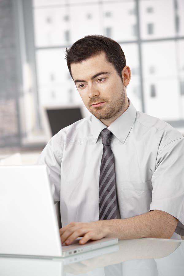 Young Man Working on Laptop in Bright Office Stock Photo - Image of ...