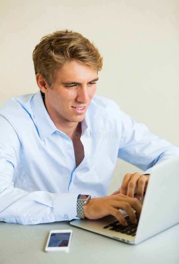 Young Man Working on Laptop Computer Talking on Phone Stock Image ...