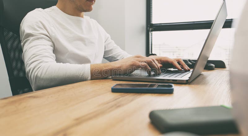 Young Man Working on Laptop Computer while Sitting in Coworking Space ...