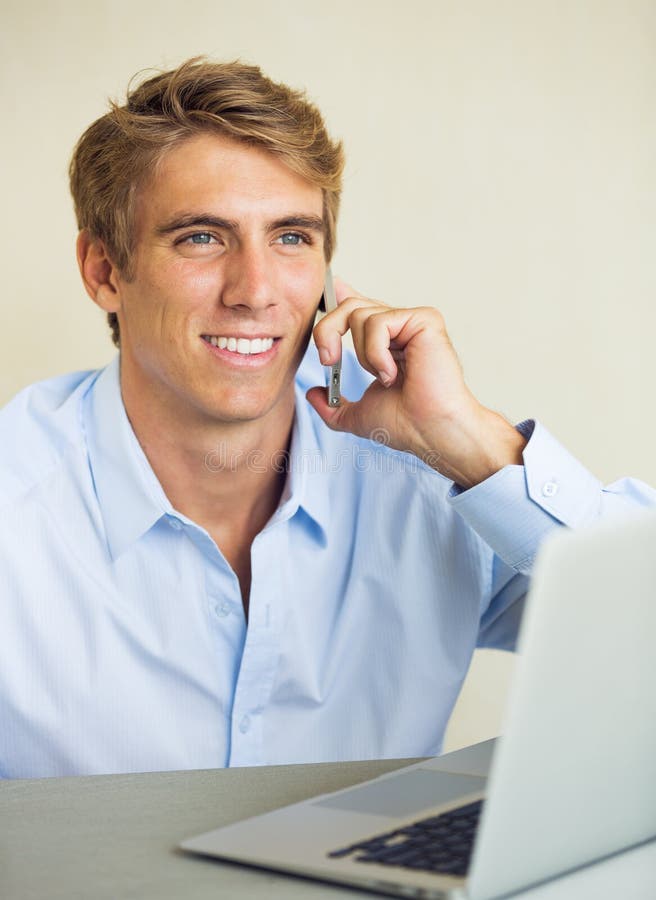 Young Man Working on Laptop Computer Talking on Phone Stock Image ...
