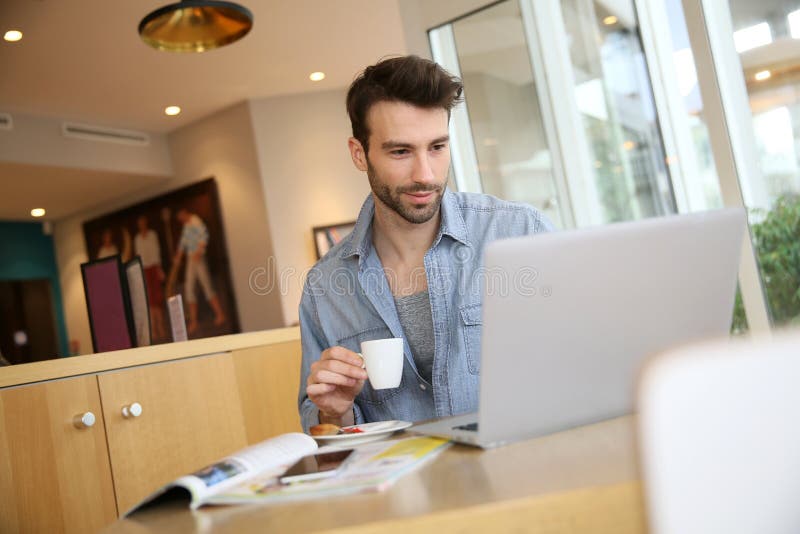Young Man Working on a Laptop Drinking Coffee Stock Image - Image of ...