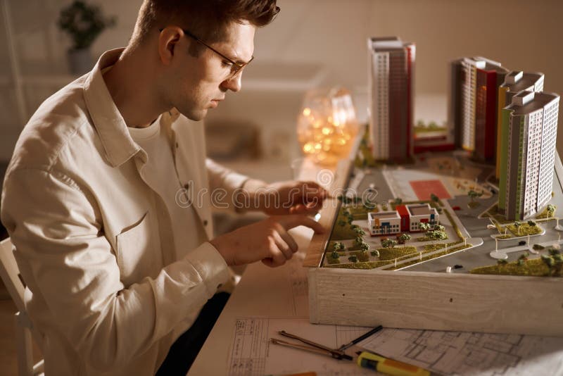 Young Man Working with a Layout of the Future Building Stock Image ...