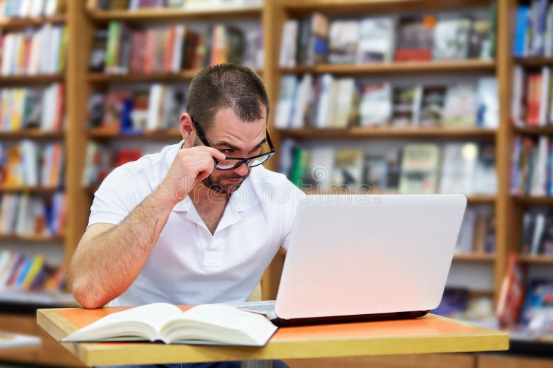 Young Man Working in a Library Stock Image - Image of computer, shirt ...