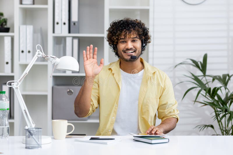 Young Man Working in a Modern Office Wearing a Headset and Waving Hello ...
