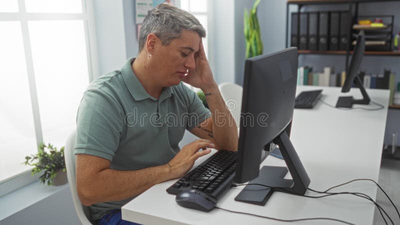 Young Man Working in an Office Looking Stressed while Using a Computer ...