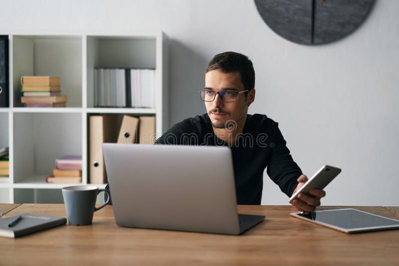 Young Man Working with Phone and Computer, Receiving Phone Call ...