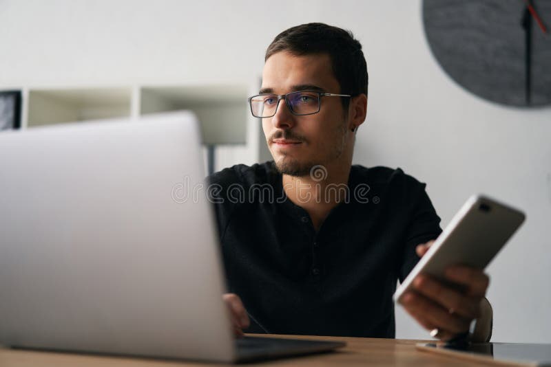 Young Man Working with Phone and Computer, Receiving Phone Call ...