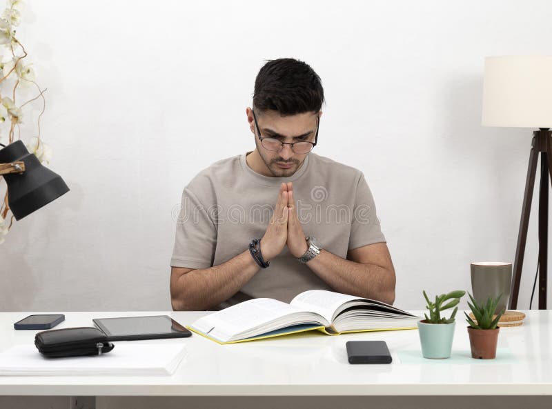 Young Man Working and Praying in His Home Office.education.business.e ...