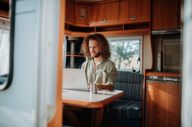 Young Man Working Remotely from Caravan. Man Using Camper As Homeoffice ...