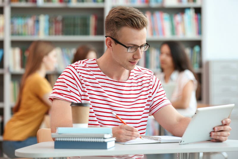 Young Man Working on Tablet at Table Stock Photo - Image of ...