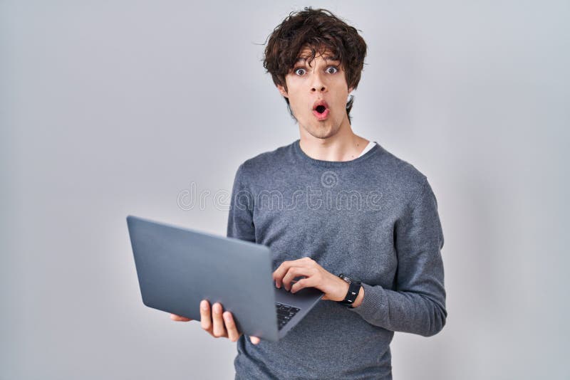 Young Man Working Using Computer Laptop Scared and Amazed with Open ...