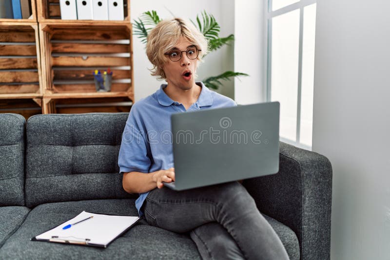 Young Man Working Using Computer Laptop Sitting on the Sofa Scared and ...