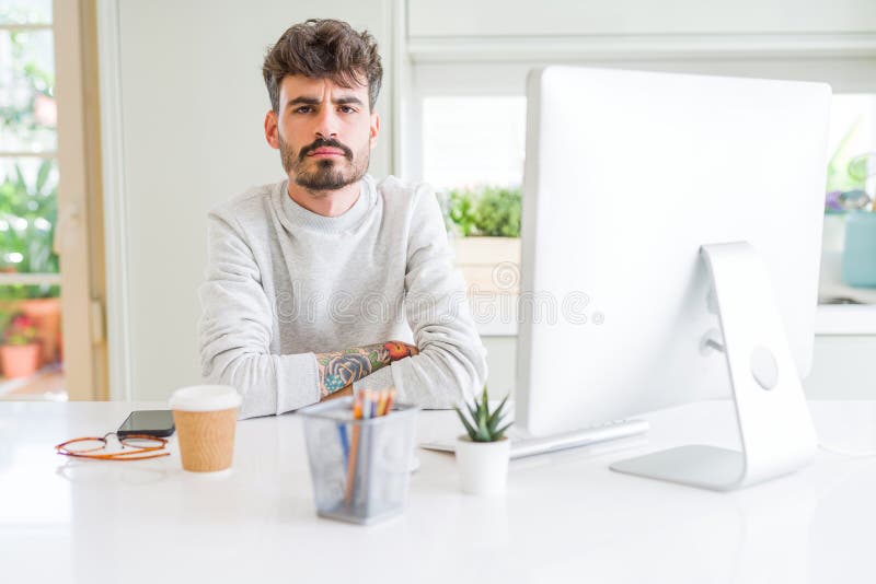 Young Man Working Using Computer Skeptic and Nervous, Disapproving ...