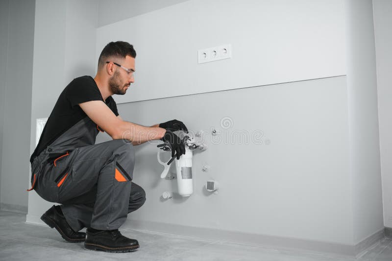 Young Man in Workwear Using Pliers while Installing Water Filtration ...
