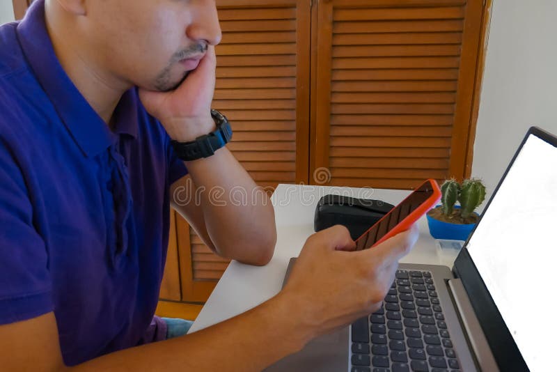 Young Man Writing on Cell Phone with Black Screen in Room, Working from ...