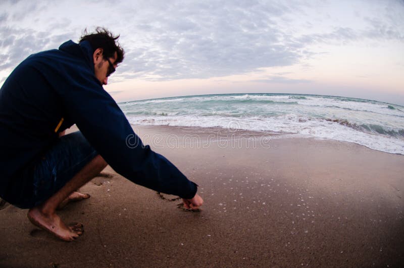 Young Man Writing a Message in the Sand at the Sea Stock Photo - Image ...