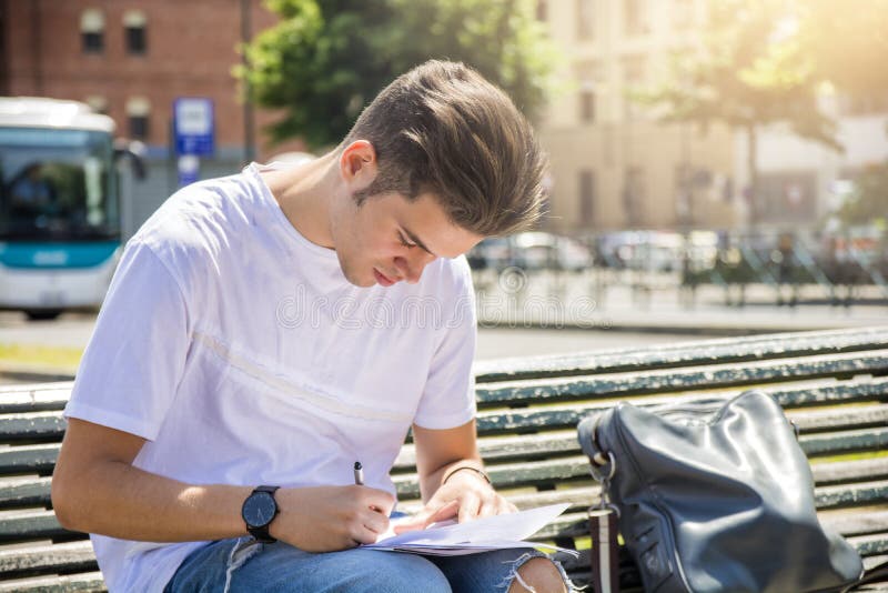 Young Man Writing Notes on Notepad in City Stock Image - Image of ...